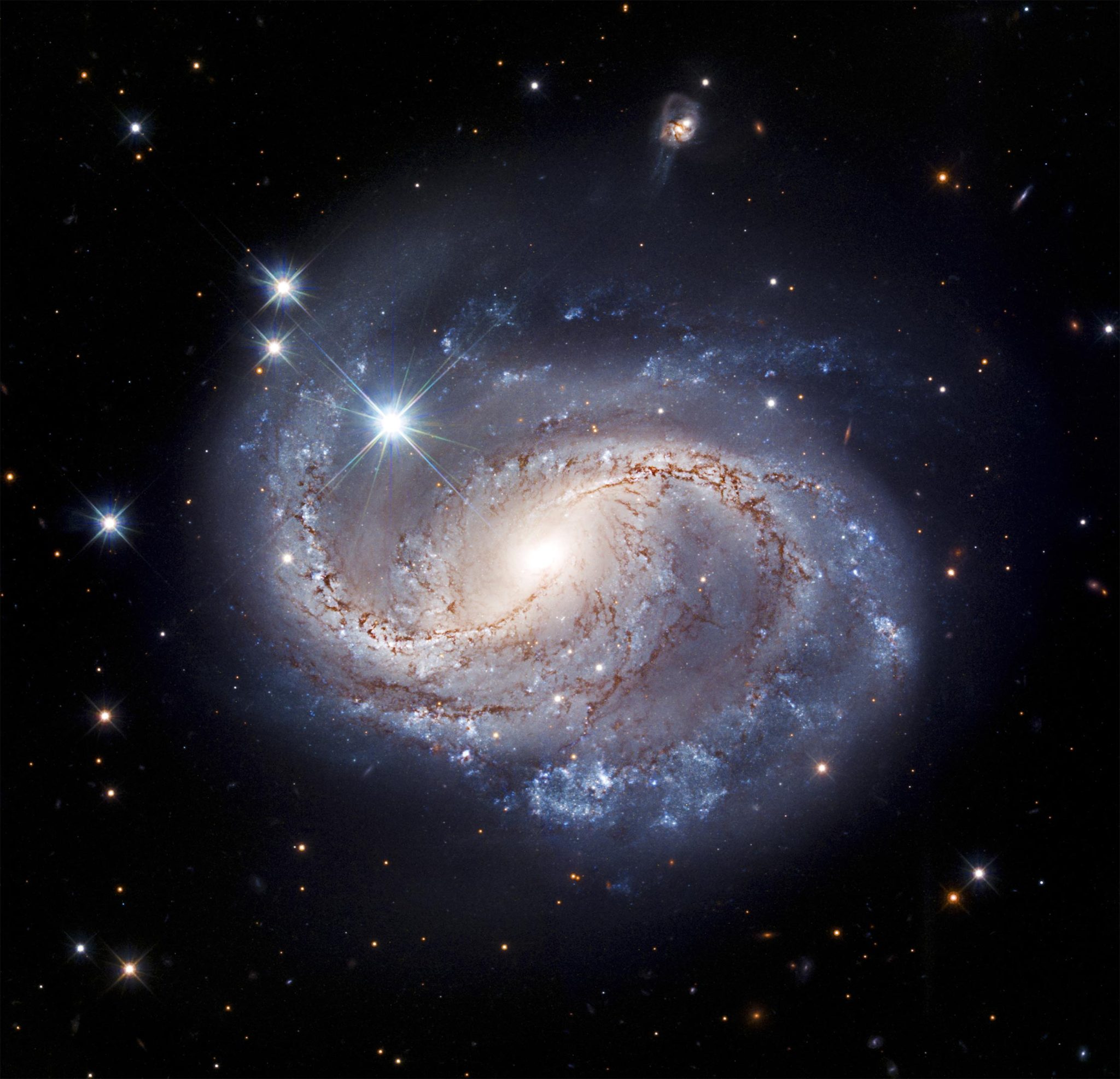 Radiant Blue Swirls: Hubble Captures Majestic Barred Spiral Galaxy